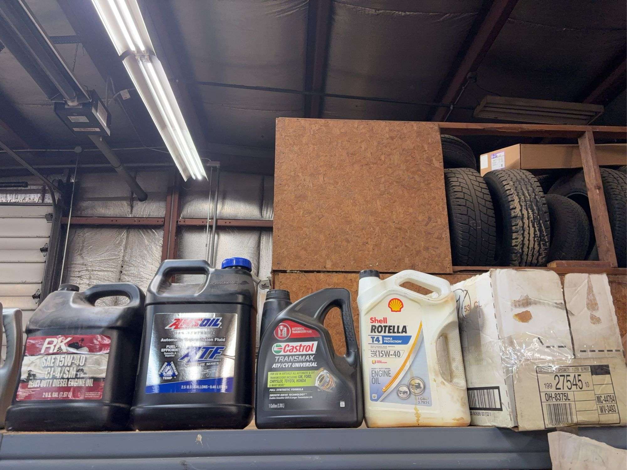 Contents of top shelf including diesel engine oil, transmission fluid ...