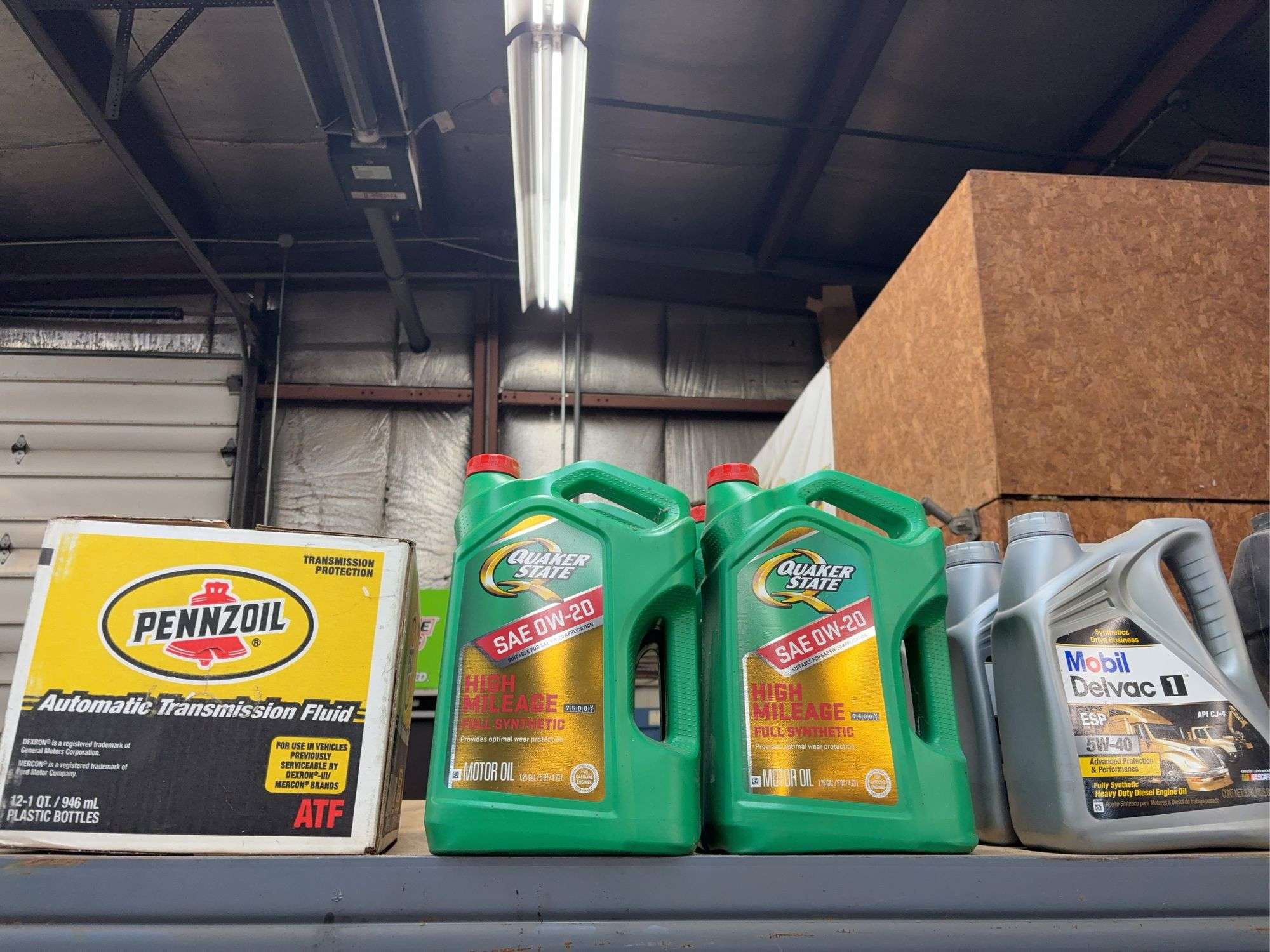 Contents of top shelf including Quaker State full synthetic oil, Mobil ...