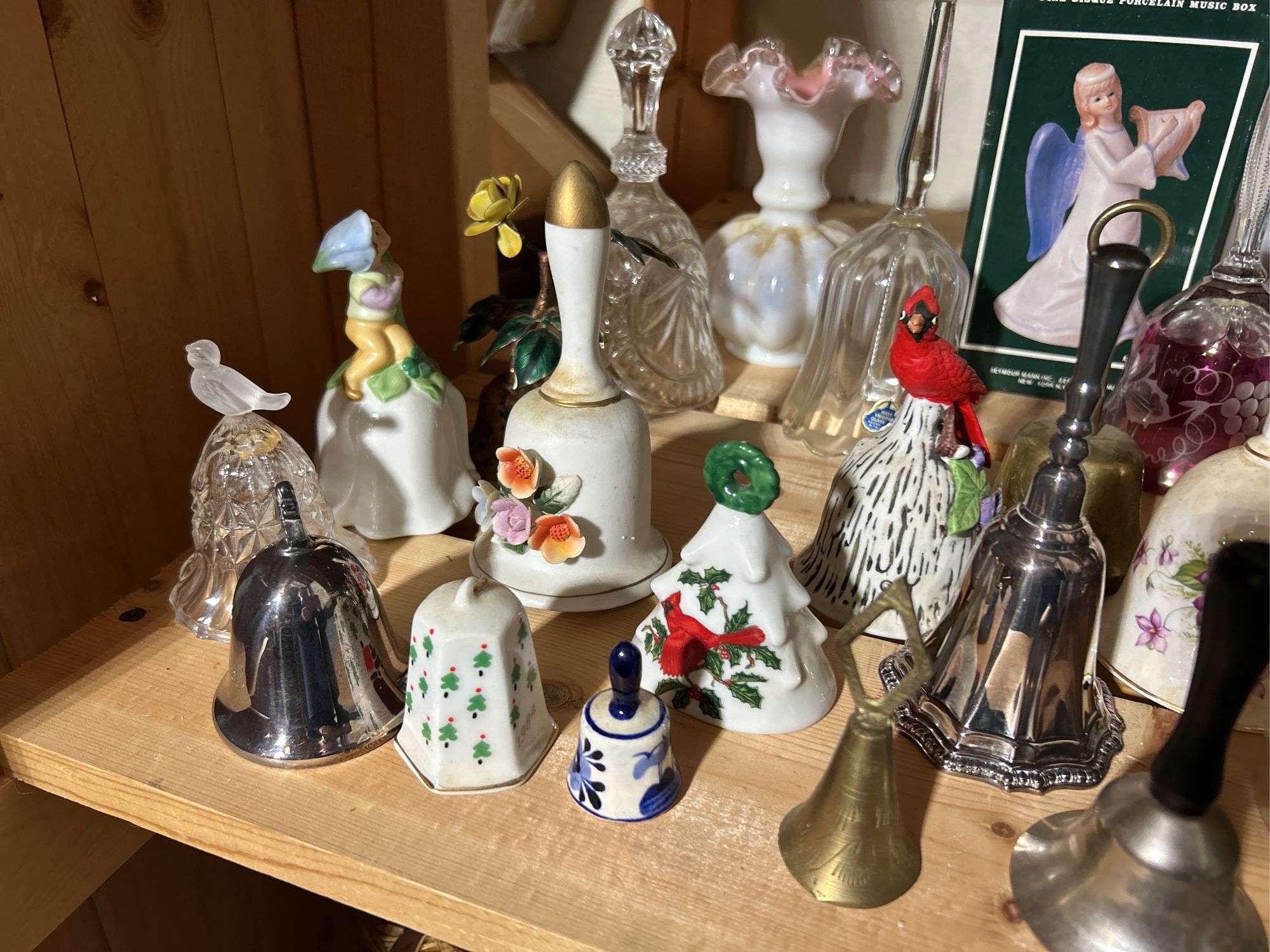 Shelf of mostly decorative glass bells including West Virginia glass ...